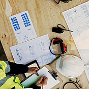 Blueprint, construction and person at table with layout, checklist and ...