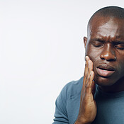 Hand, sick and black man with toothache in studio for dental injury ...