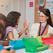 High five, learning or study with students and teacher in classroom of ...
