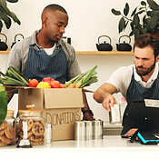 Business aid, donations and men in cafe, sorting and food distribution ...