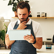 Man, thinking and barista with tablet in cafe for reading, problem ...
