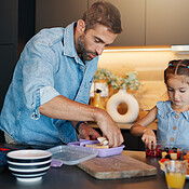 Dad, girl and packing lunch box in kitchen with sandwich, fruit and ...