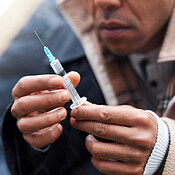 Hands, poverty and homeless with needle, drugs and tent with addiction ...