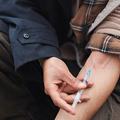 Hands, syringe and homeless with injection, drugs and addiction with ...