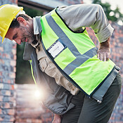 Man, construction worker and back pain with injury, work site accident ...