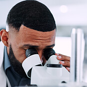 Man, forensic and scientist with microscope for exam, clinic trial or ...