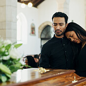 Couple, coffin and embrace at funeral for death, pay respect or comfort ...