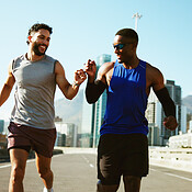 Happy men, running and city with fist bump for workout, exercise or ...