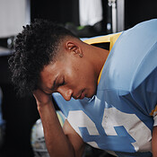 Man, American football player and headache with stress in locker room ...