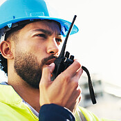 Construction site, radio and man with engineering, talking and ...
