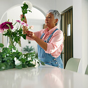 Senior woman, arrangement and flowers at house for special occasion ...