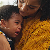 Crying, comfort and mom with child on sofa with pain for teething ...