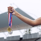 Sport, winner and hands of athlete with medals at stadium for track ...