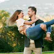 Couple, lift and hug with happiness in garden, celebration or energy ...