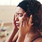 Woman, headache and stress with pain in gym for muscle tension or ...