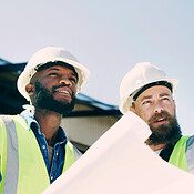 Construction, team and men on worksite with blueprints, consultation ...