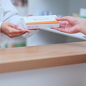 Pharmacist handing prescription medication, pills or medicine to ...