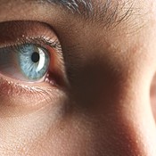 Zoom of Caucasian woman, blue eye blink in optical or vision wellness ...