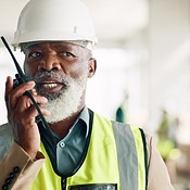 Senior engineer, walkie talkie and black man at construction site ...