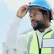 Black man, engineer and safety helmet in the city for construction ...