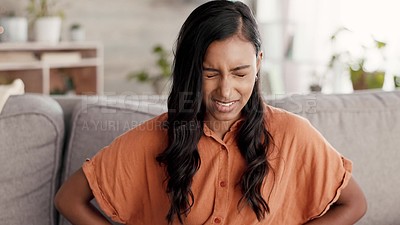 Black woman, stomach pain and sofa in home living room with frustrated ...