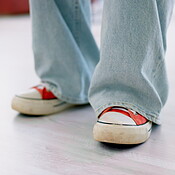 Foot, tapping and waiting for a bored person sitting alone at a desk ...