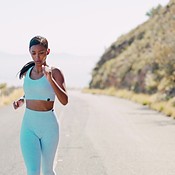 Fitness, endurance and woman running in a road tired, focused and ...