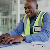 Typing architect, laptop and happy black man planning infrastructure ...