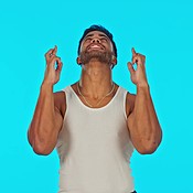 Praying, hope and portrait of a man with desperation isolated on a blue ...