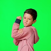 Strong, face and child in a studio with green screen flexing his arm ...