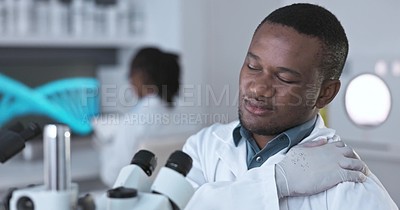 Black man scientist, laboratory microscope and shoulder pain of a ...