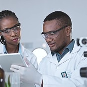 Scientist, tablet and teamwork of people in laboratory for analysis ...