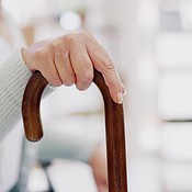 Hand, walking stick and closeup for woman in living room, nursing home or hospital for mobility ...