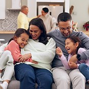 Jump, hug and family on a sofa with love, happy and bonding in their ...