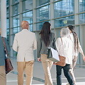 Back view, team and business people walking and talking as travel or ...