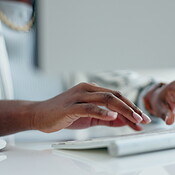 Receptionist, typing and hands on keyboard in office with employee ...