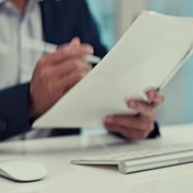 Hands, documents and a business man typing on a keyboard while marking ...