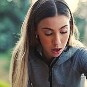 Running, fitness and tired woman in a forest for training, workout and ...