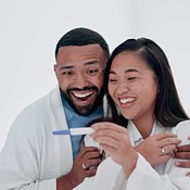 Pregnancy test, wow and excited couple hug in a bathroom in celebration ...