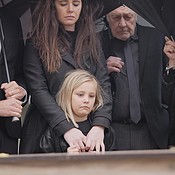 Loss, grief and people at funeral with umbrella, flowers and coffin ...