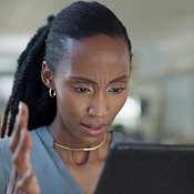 Confused, black woman and tablet in office, problem and typing to ...