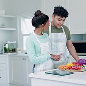 Cooking, couple and conversation in kitchen with vegetables and food ...