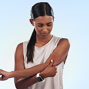 Injury, arm and woman with fitness, pain and inflammation on a blue ...