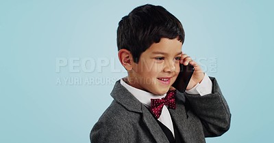 Child, talking and boy with phone call in studio, blue background and ...