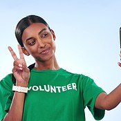 Volunteer woman, selfie and smile in studio with peace sign, emoji and ...