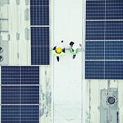 Overhead, solar energy and a construction worker team on the roof of a ...