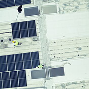 Overhead, solar power and a construction worker team on the roof of a ...