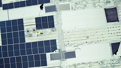 Overhead, solar energy and a construction worker team on the roof of a ...