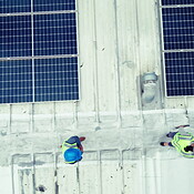 Overhead, solar energy and construction teamwork on the roof of a ...