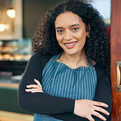 Entrance, arms crossed and restaurant woman, happy cafe waitress or ...